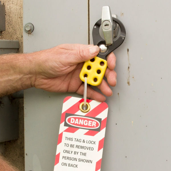 Worker tagging out an electrical panel.
